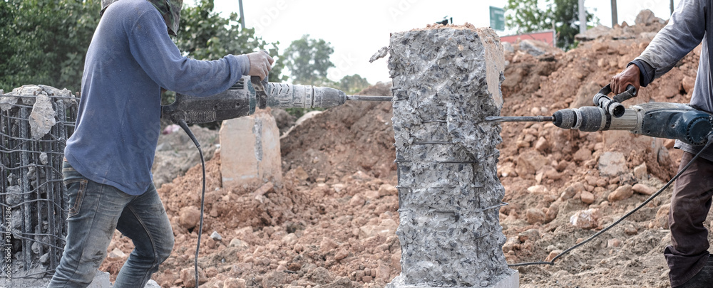 Builder workers using pneumatic hammer drill equipment breaking ...