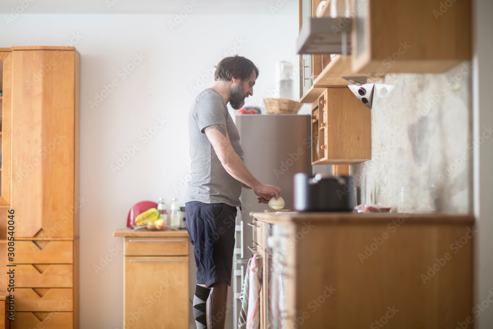 older man with prosthetic leg cooking in a kitchen Stock Photo | Adobe ...