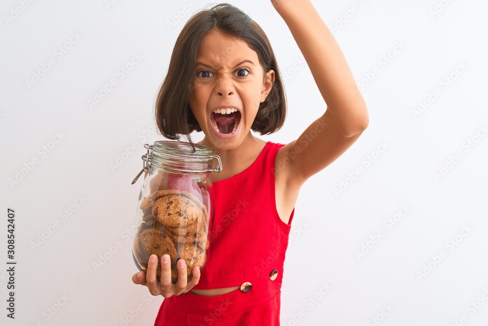 Beautiful child girl holding jar of cookies standing over isolated ...
