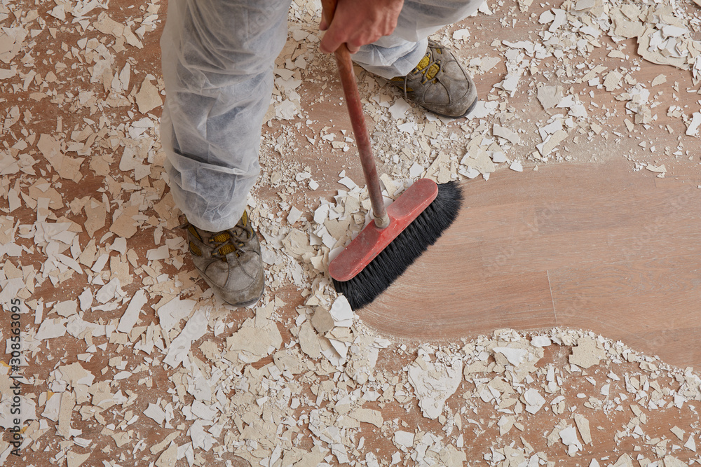 Builder sweeping the floor after renovation Stock Photo | Adobe Stock
