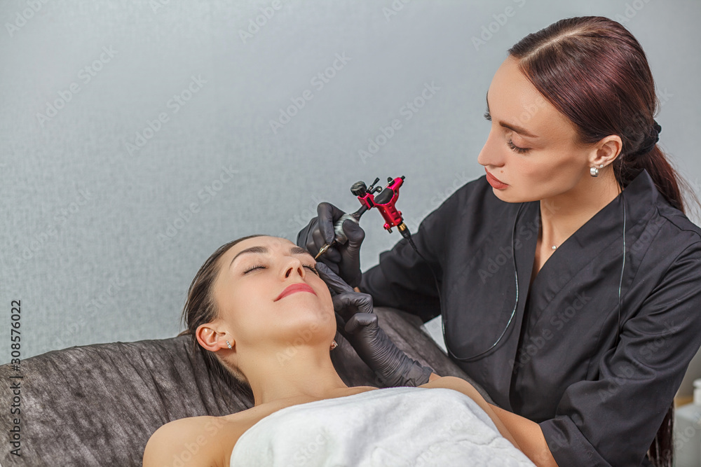 Permanent make up procedure, applying on young girl. Beautiful woman ...