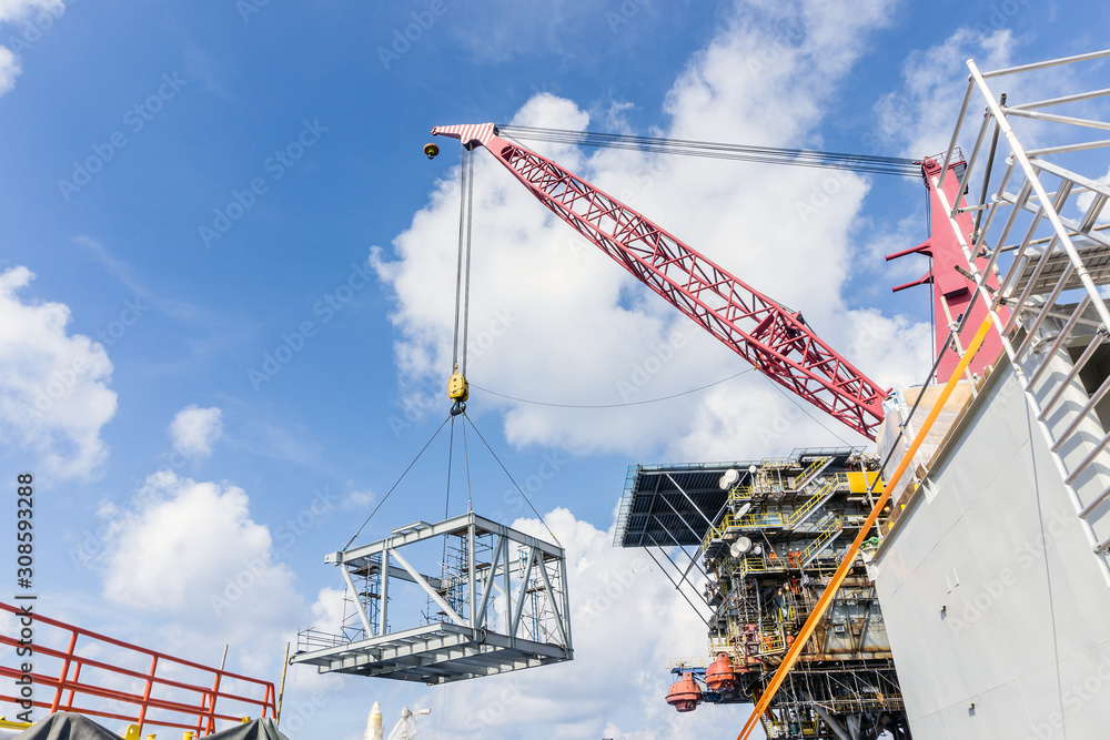 Offshore crane on board a construction work barge performing heavy ...