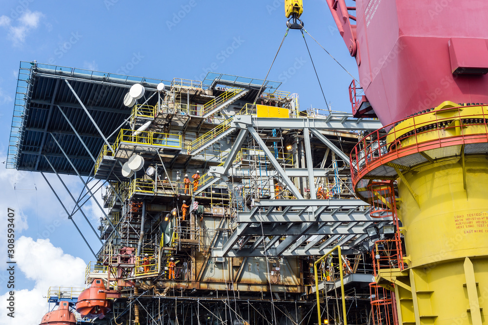 Offshore crane on board a construction work barge performing heavy ...