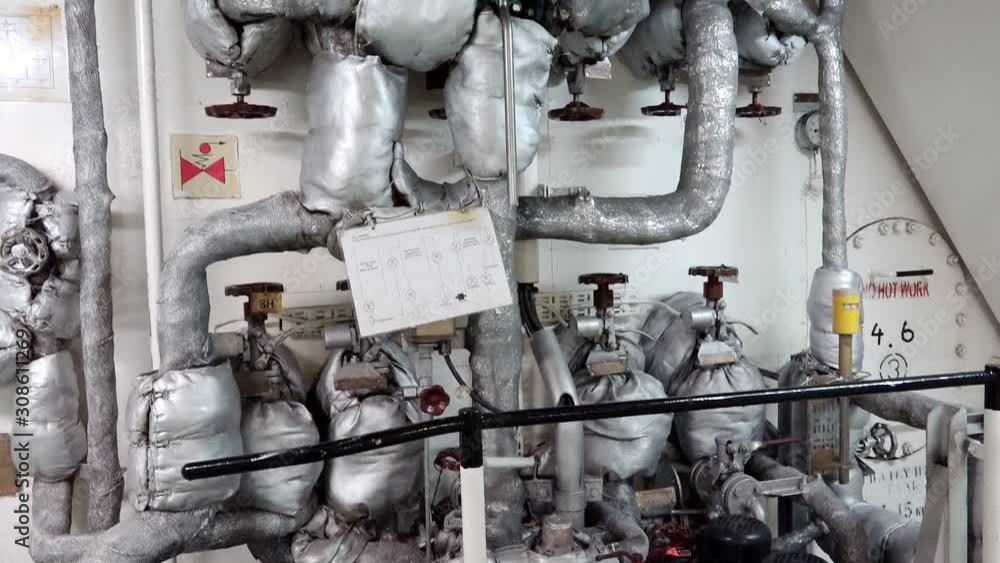 thin and thick white pipes with grey isolation and round valves of ...