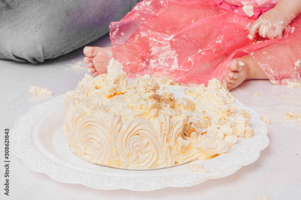 little girl eating cake with her hands on white background. The child ...