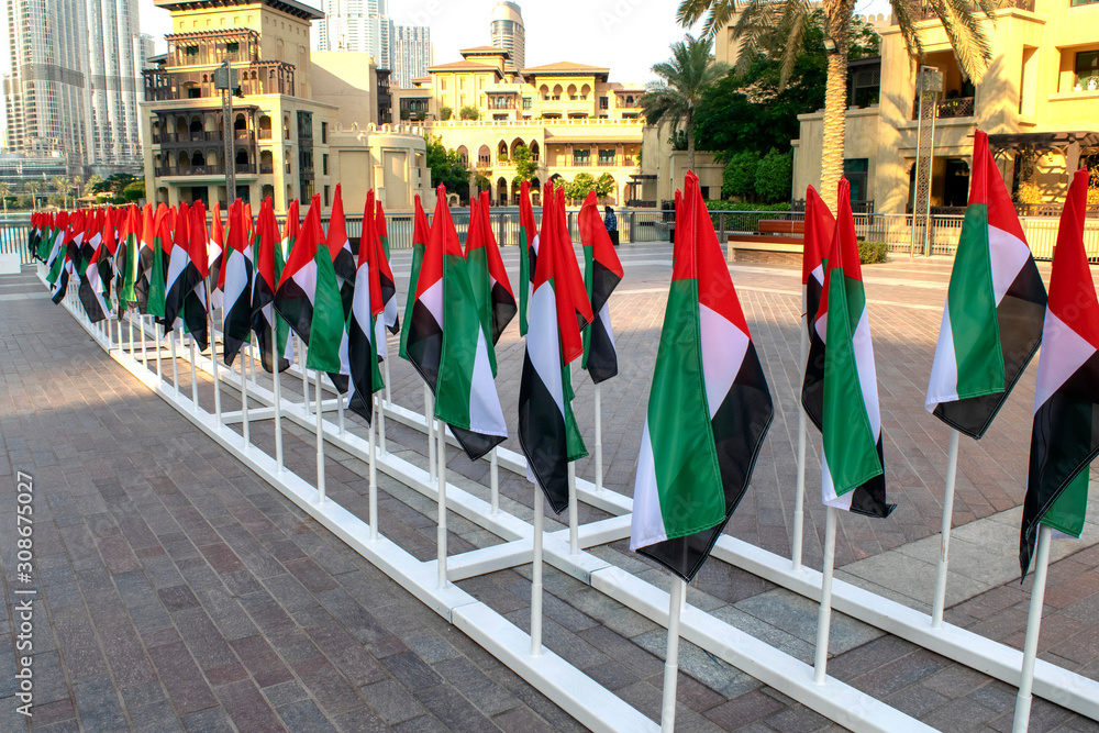 Many UAE national flags on Dubai city background. UAE National day ...