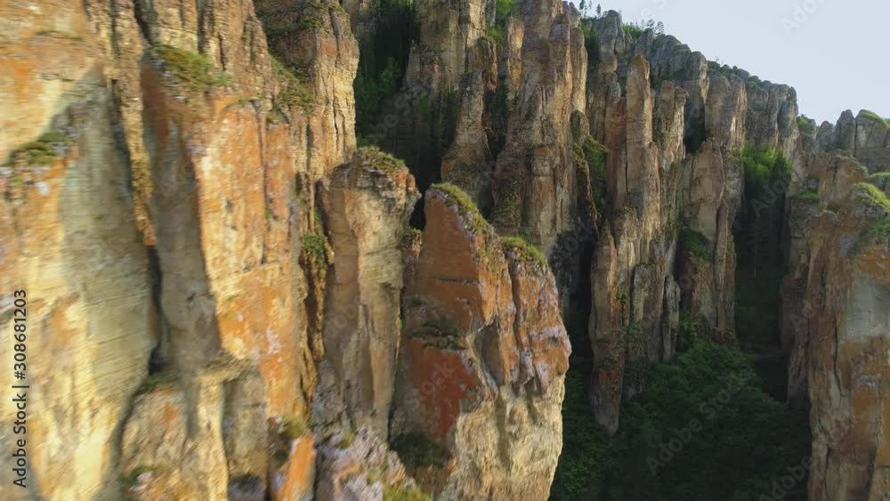 Flight low above Lena pillars epic peaks of rock formations covered ...