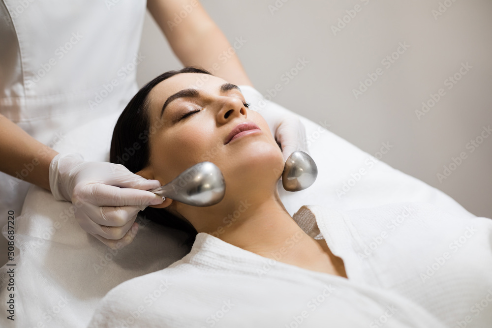 Cold therapy. Top view of nice woman lying on the bed while having her ...