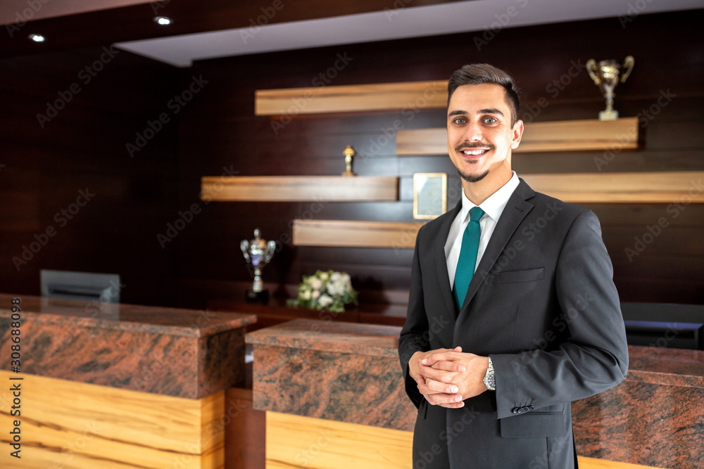 Smiling hotel worker welcoming guests Stock Photo | Adobe Stock