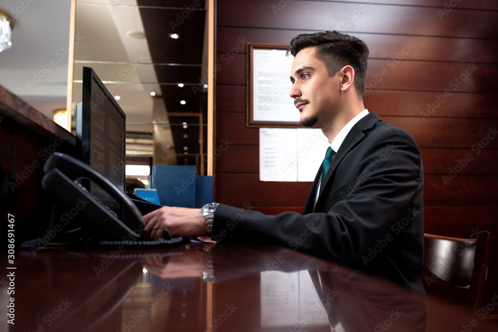 Hotel receptionist upholding his responsibilities and managing guests ...