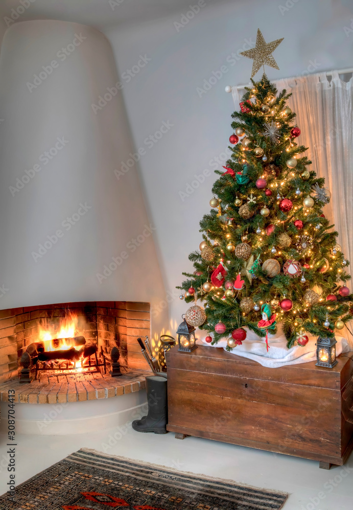 Christmas tree with burning log fire in the background. Stock image ...