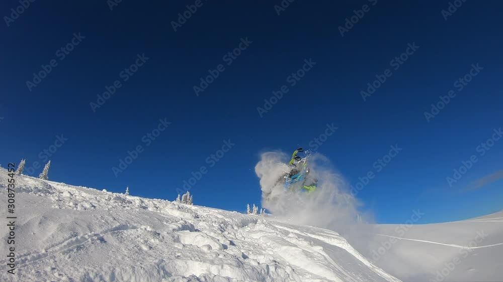 SLOW MOTION: a Pro snowmobiler makes a jump with a big blast of snow ...