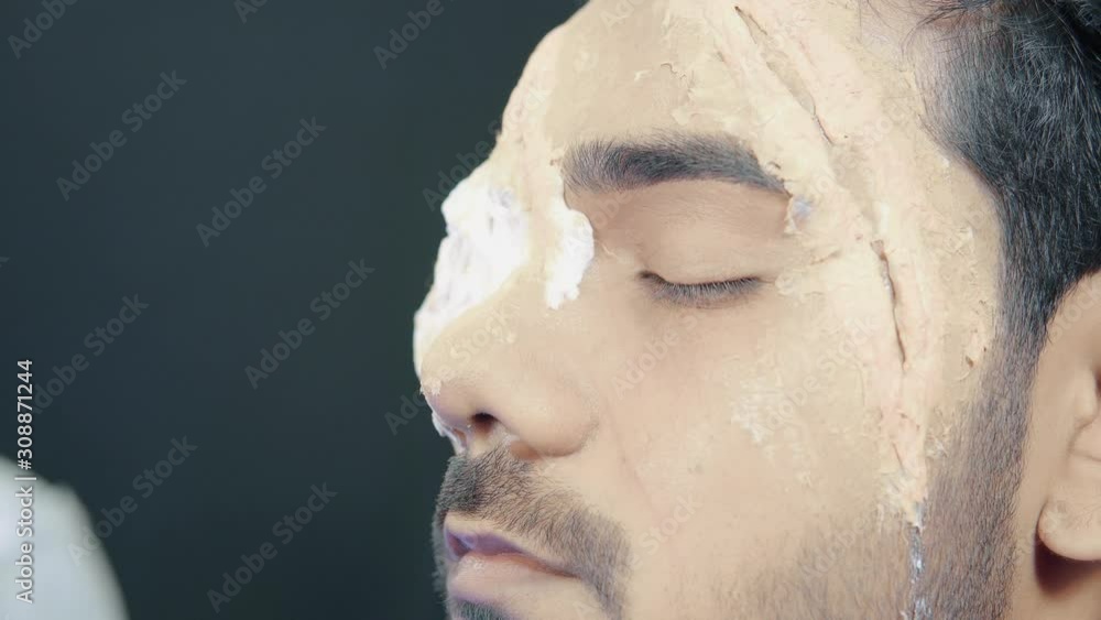 Make up artist fixing prosthetic inserts on man's face for Halloween ...