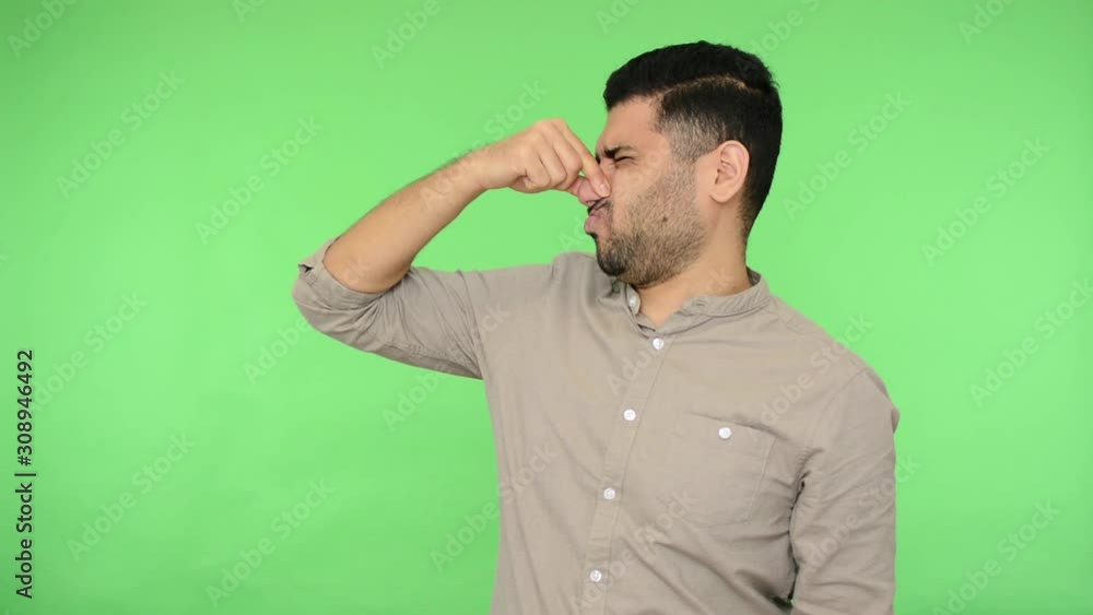 Confused disgusted brunette man with bristle in shirt pinching nose and ...
