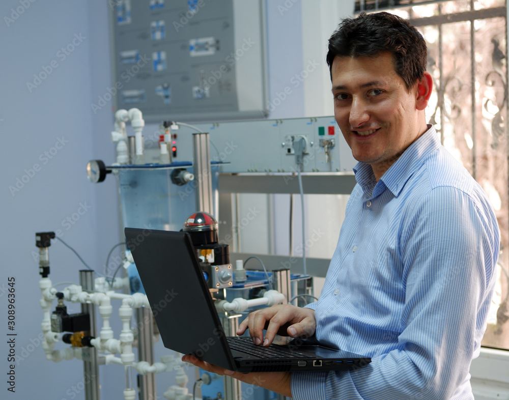 Foto de Engineer is programming PLC with his laptop for an analog ...