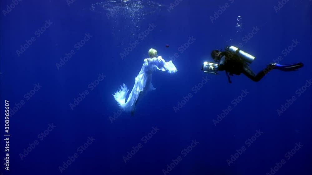 Angel young woman underwater model free diver in white cloth and ...