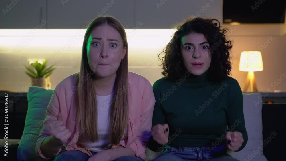Excited female fans watching football match on tv, supporting team ...