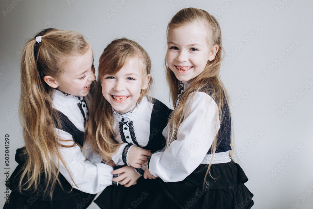 Happy cute adorable triplets girls posing in studio together on ...