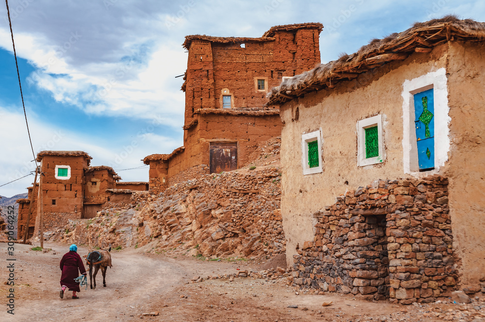 View of adobe houses in the high snow-capped mountains in the Aït ...