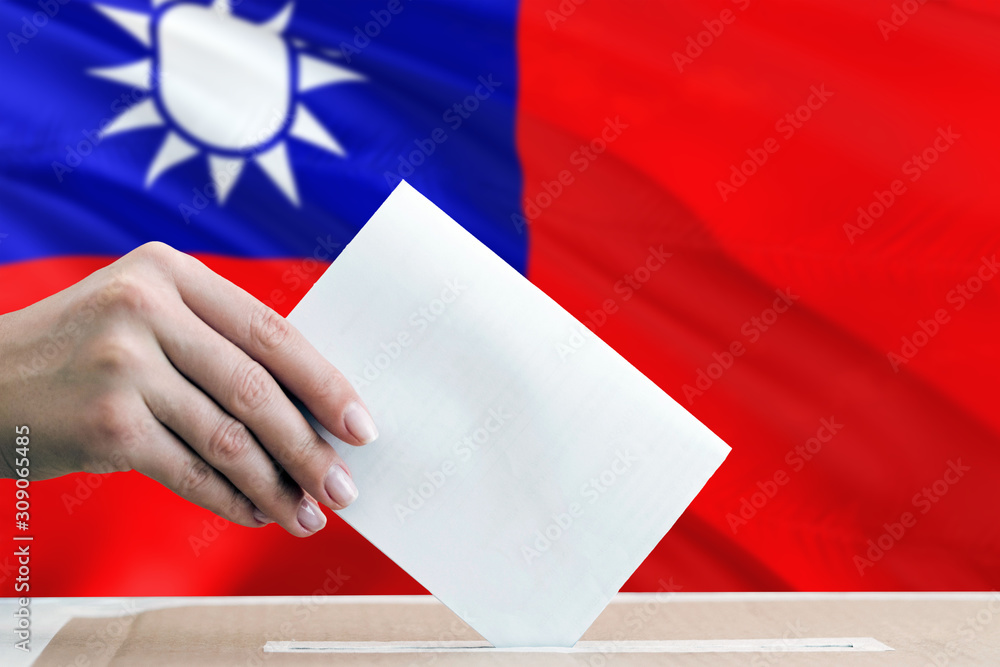 Taiwan election concept. Side view woman putting a ballot in a box on ...