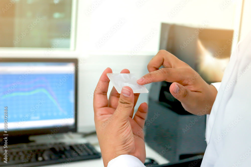 Hand holding sheet PMMA acrylic plate to apply sunscreen for ...