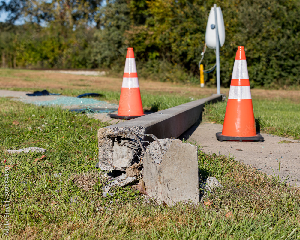 Concrete streetlight pole broken from car accident laying across ...