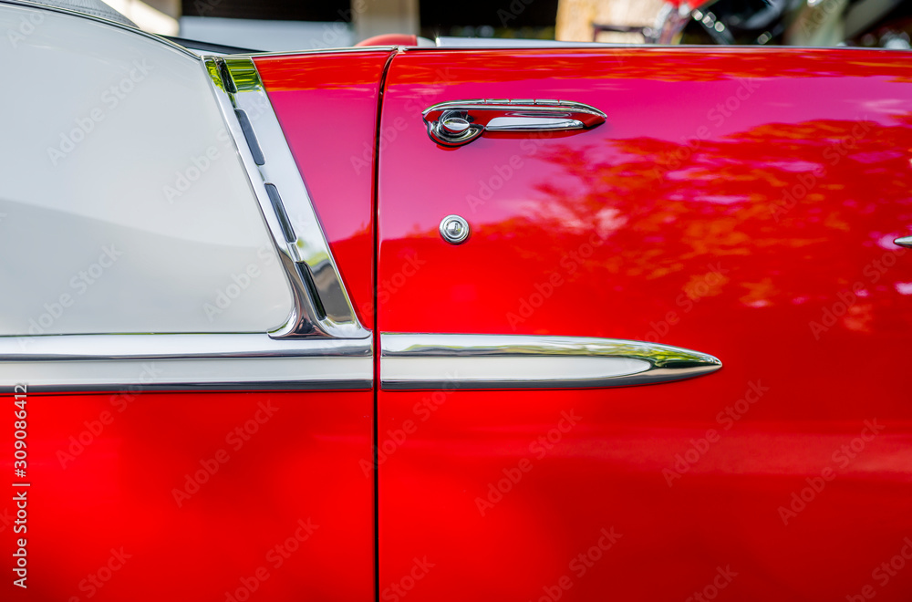Side of an open bright red vintage retro convertible car with chrome ...