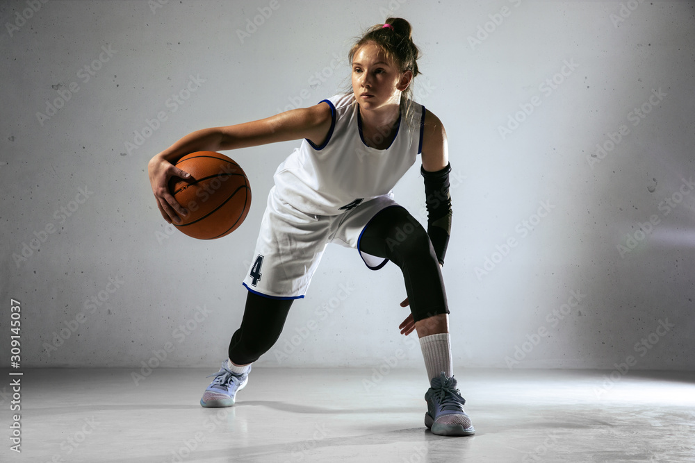 Young caucasian female basketball player of team in action, motion in ...