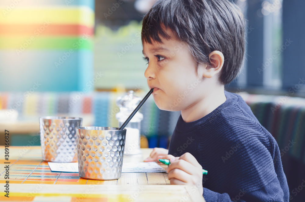Portrait uhhappy kid drinking cold drink in restaurant,Toodler with ...