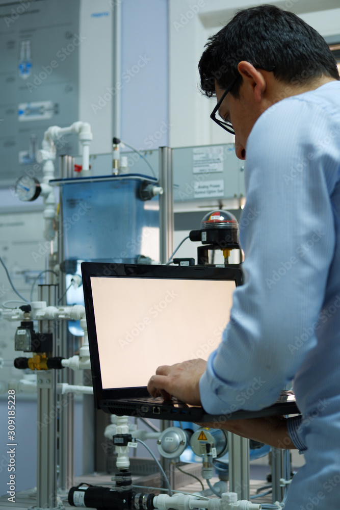 Focus on PLC programming Engineer's laptop's blank screen and analog ...