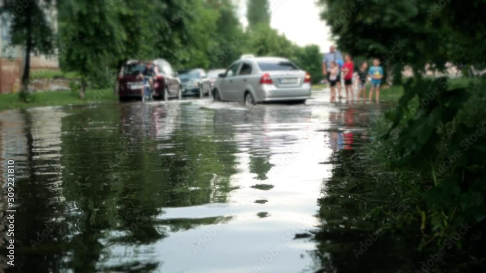 People children barefoot in dirty water on the flooded city street ...