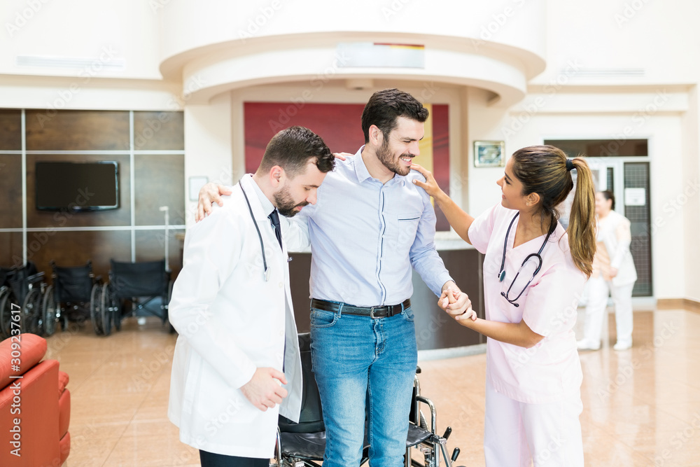 Doctors Supporting Man To Stand While Saying Goodbye At Hospital Stock ...