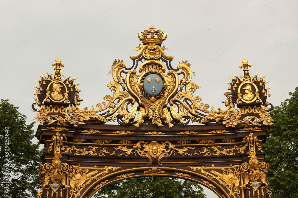 A royal crown on top of the golden decorated gilded wrought iron gates ...