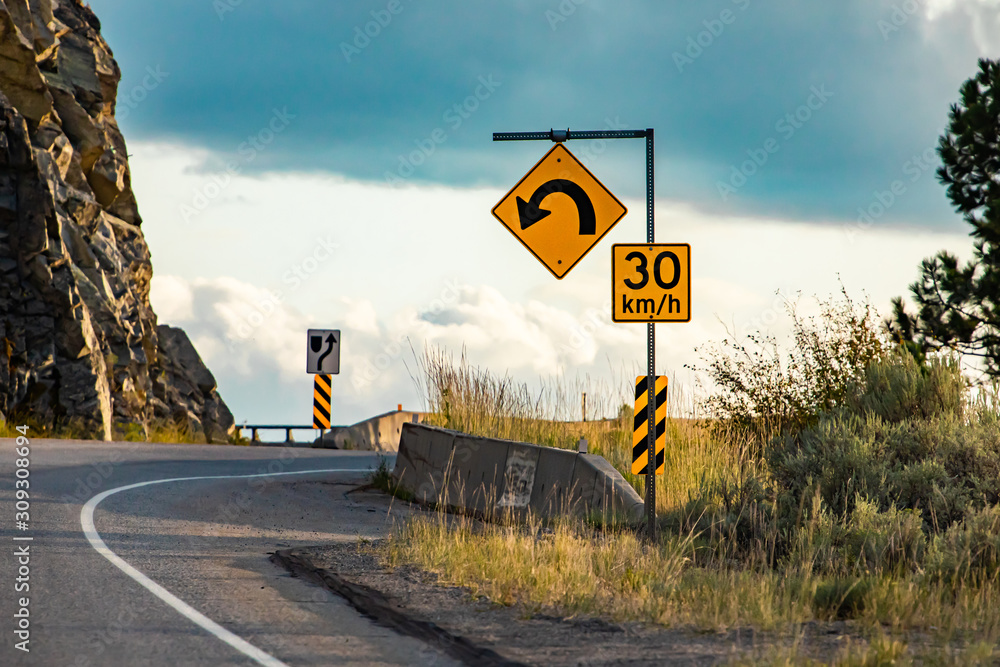 Yellow warning road sign u-turn with 30 km per hour maximum speed ...