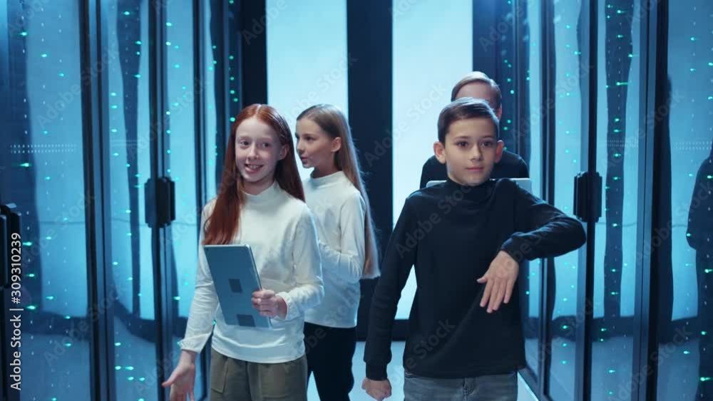 Team of adorable school children having fun inside server cabinet ...