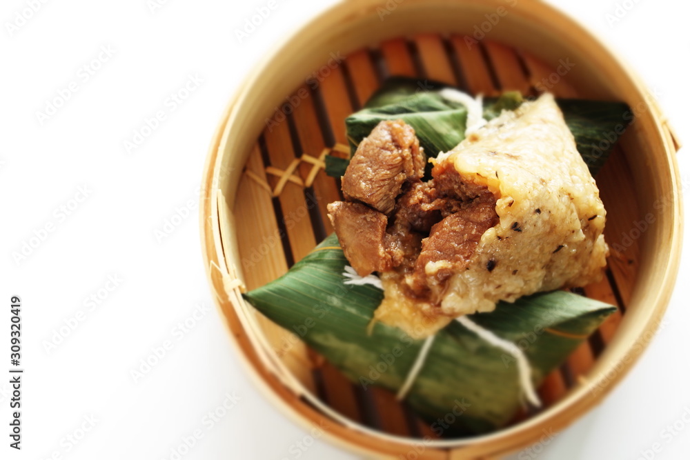 Chinese dumpling, meat and sticky rice wrapped zongzi in bamboo basket ...