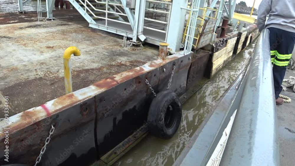 Man moor barge. The sailor ties the mooring rope of the ferry to a ...