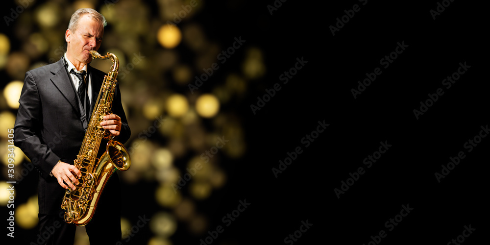Saxophone player isolated at the left border of a black background ...