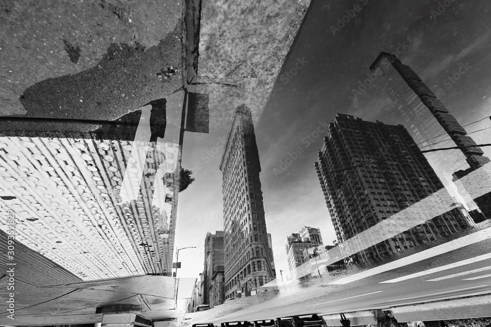 Manhattan in puddle reflection with pedestrians, traffic lights ...