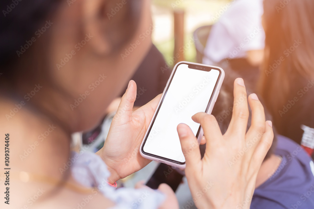 Asian woman is using a smartphone in a coffee shop with white sceen and ...