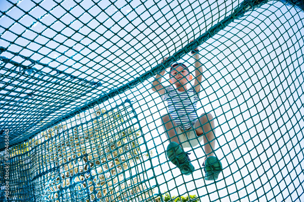 Little boy enjoy climbing the net in playground under sunshine Stock ...
