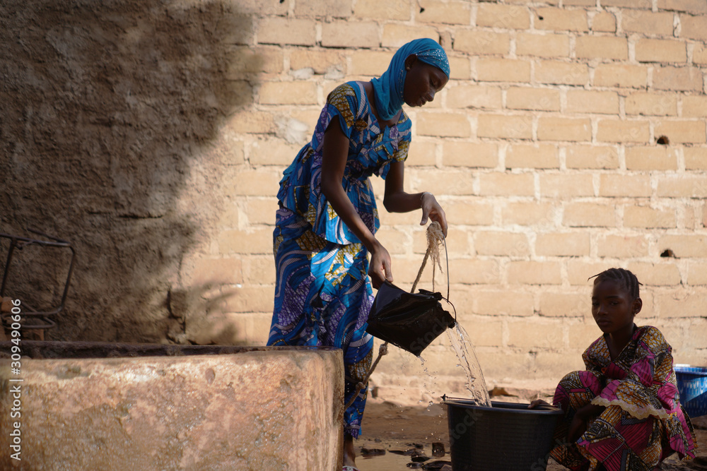 Pouring Water into Bucket as a African Poverty Symbol Stock Photo ...