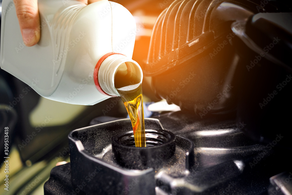 Refueling and pouring oil quality into the engine motor car ...
