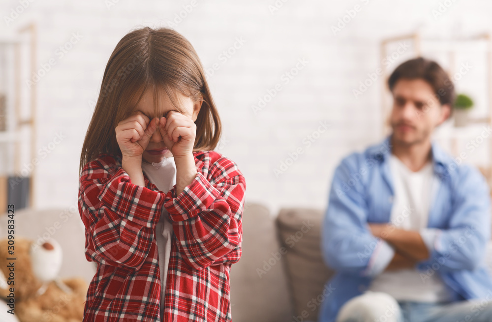 Little girl crying after quarrel wIth father, angry dad behind Stock ...