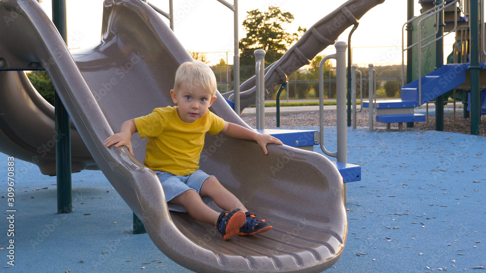 Little boy (toddler, two years old kid) having fun, sliding down ...