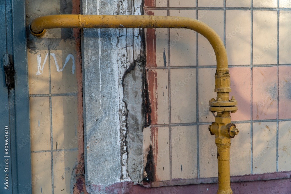 Foto de Little gas crane on the curved pipe near wall with tiles and ...
