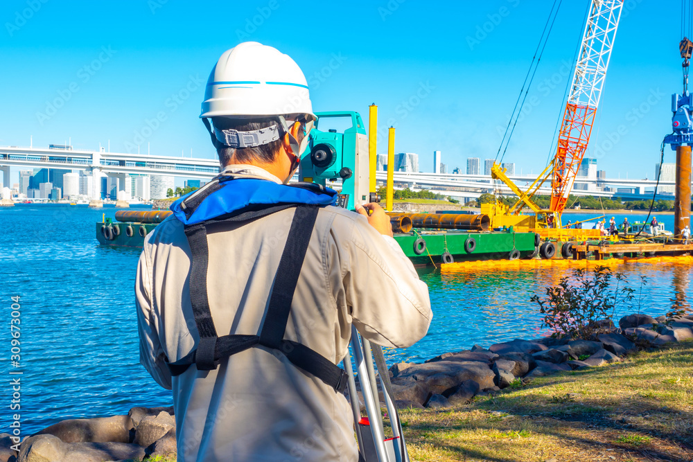 A man works with a theodolite. Mapping the instrument on the tripod ... A man works with a theodolite. Mapping the instrument on the tripod ...