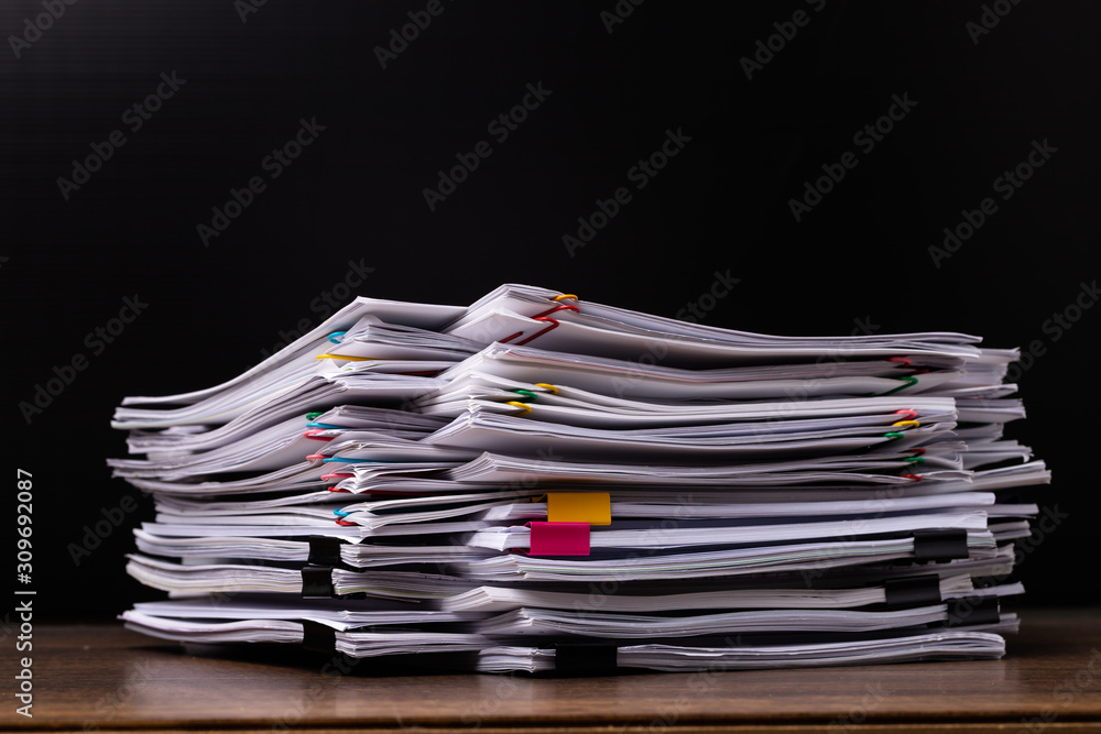 Stack overload document report paper with colorful paperclip on black ...