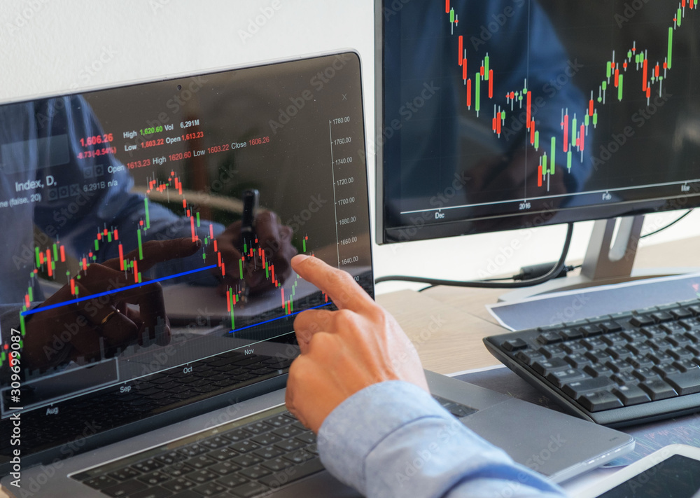 Trading on the table is working on a computer screen full of charts and ...