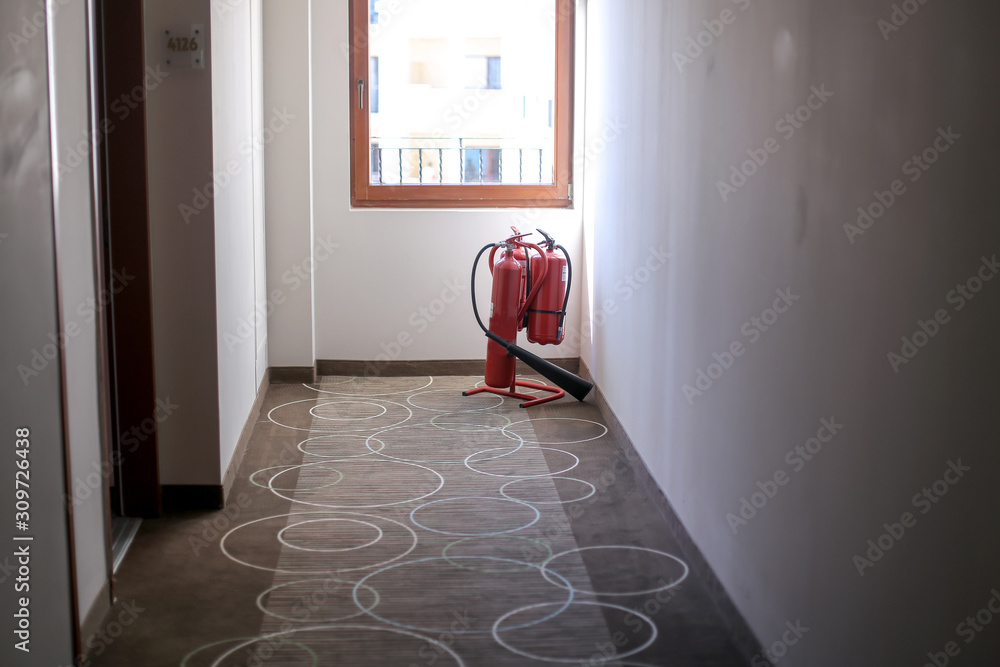 Different types of fire extinguishers on the hallway of a hotel Stock ...